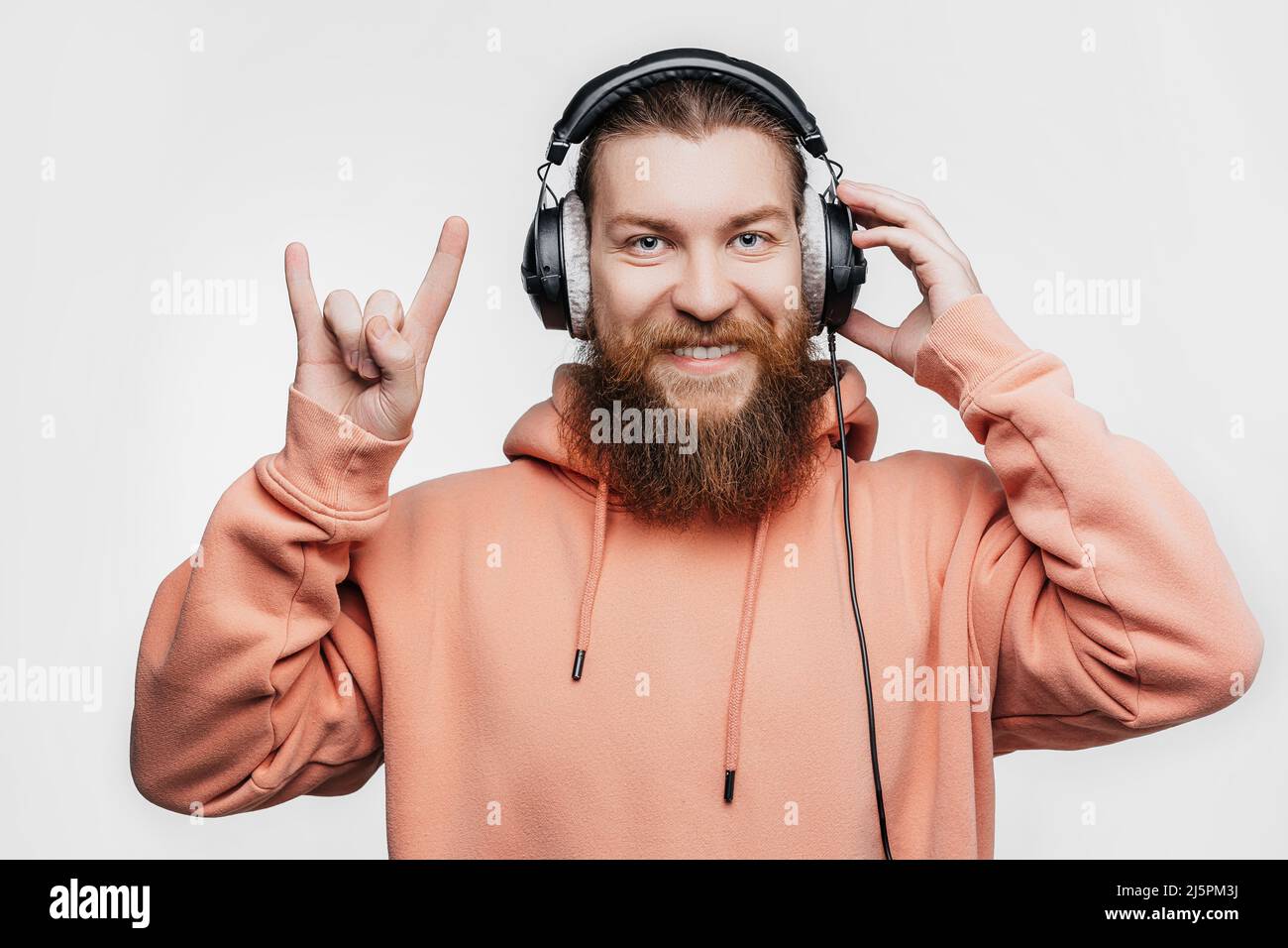 Scandinavian handsome man shows sign of the horns gesture smiles and ...
