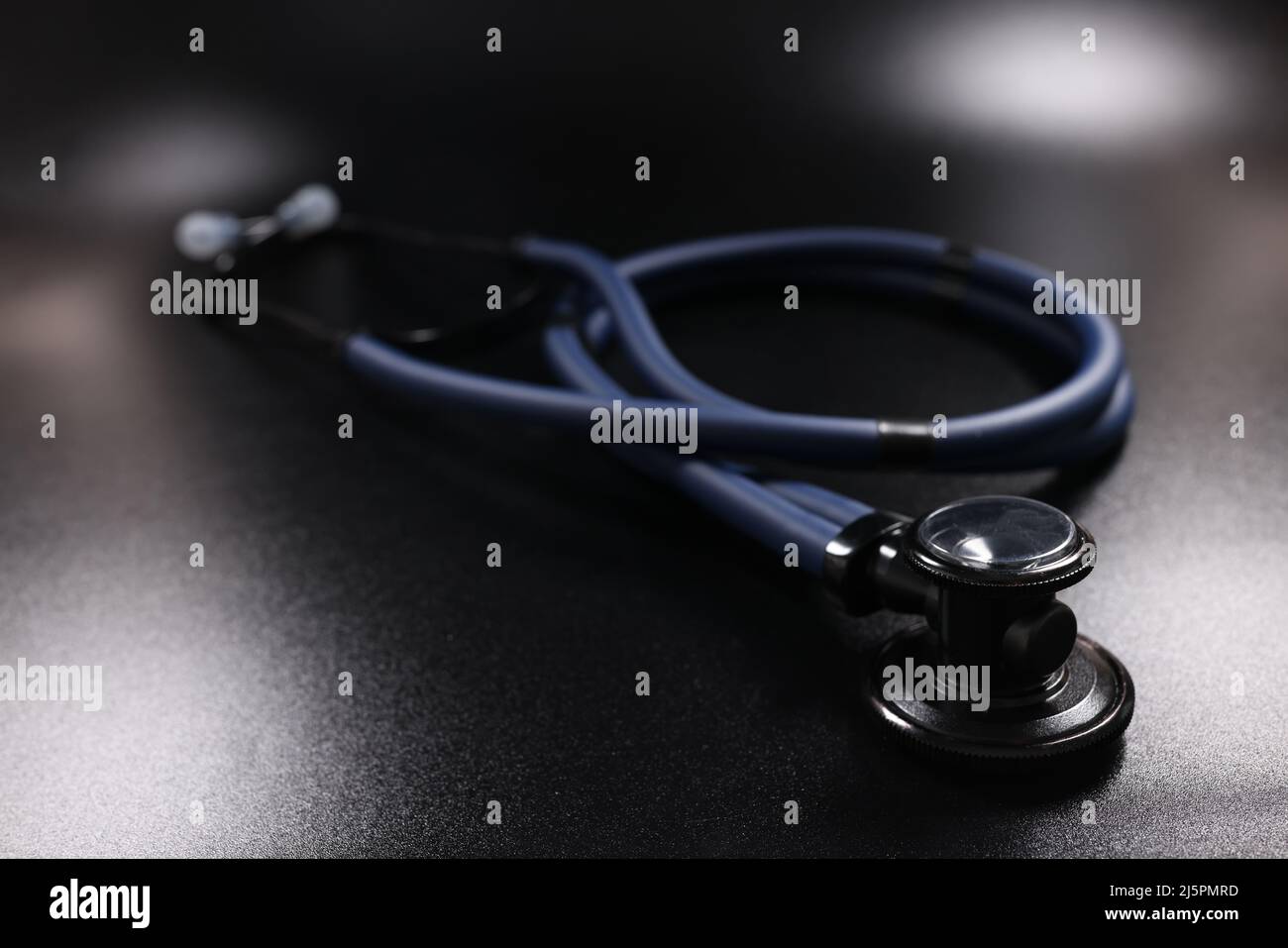 Dark blue medical stethoscope on black surface Stock Photo - Alamy
