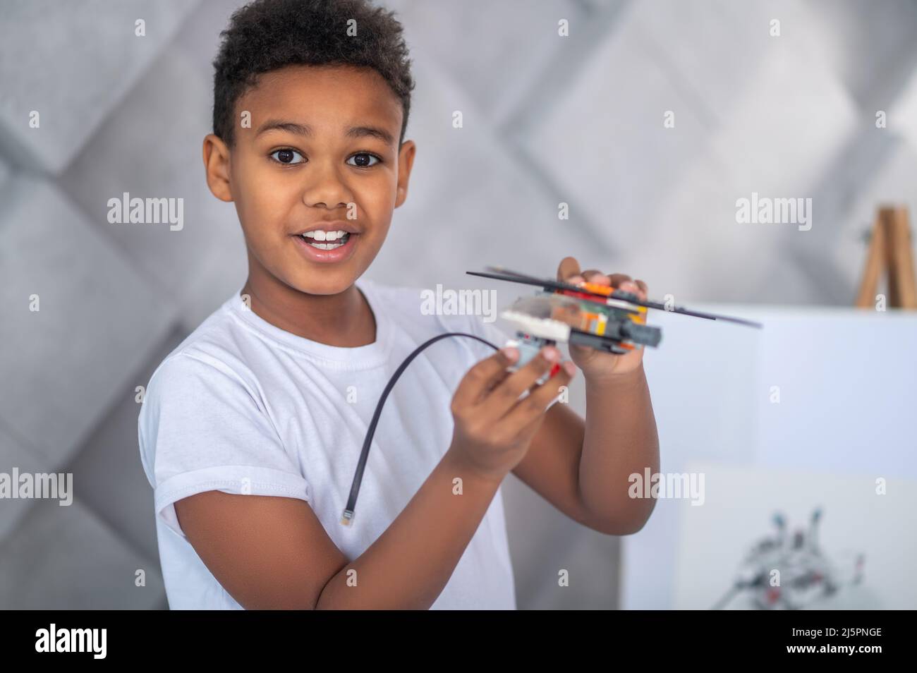 A cute teen looking busy while assembling toy heicopter parts Stock ...