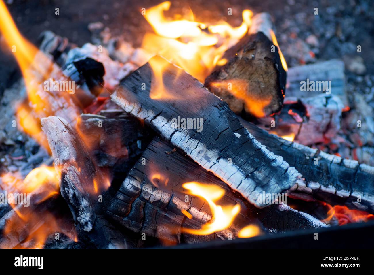 Burning red coals and black charred wood. Red burning coals as a ...
