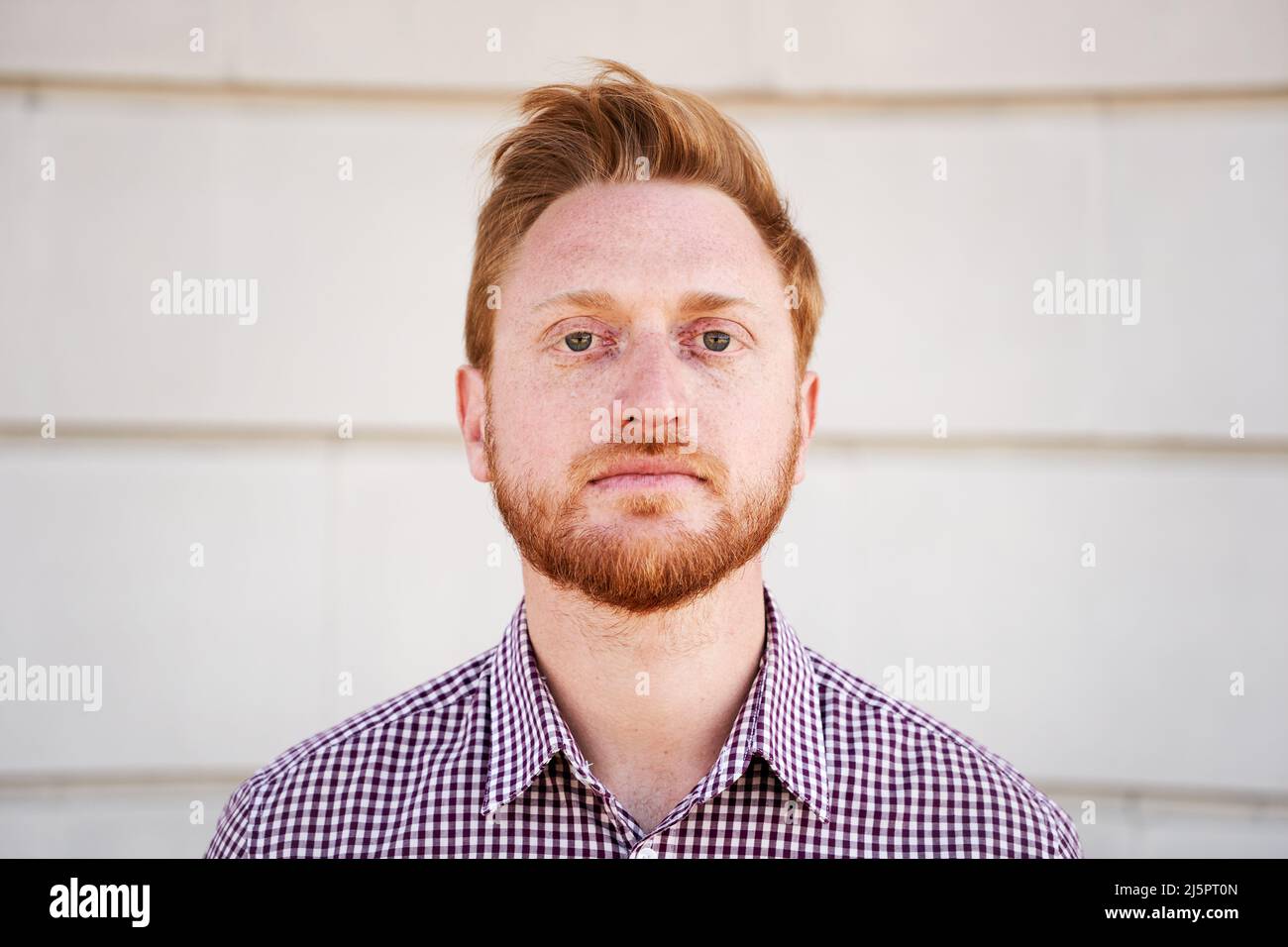 Outdoor portrait of a Red hair guy looking at the camera serious with ...