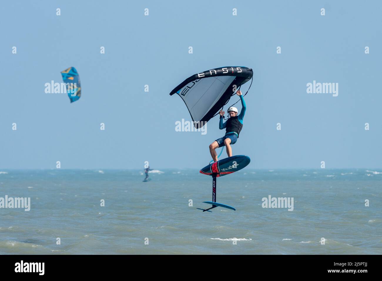 A wing surfer on a hydrofoil board jumping out of the water in the Gulf ...
