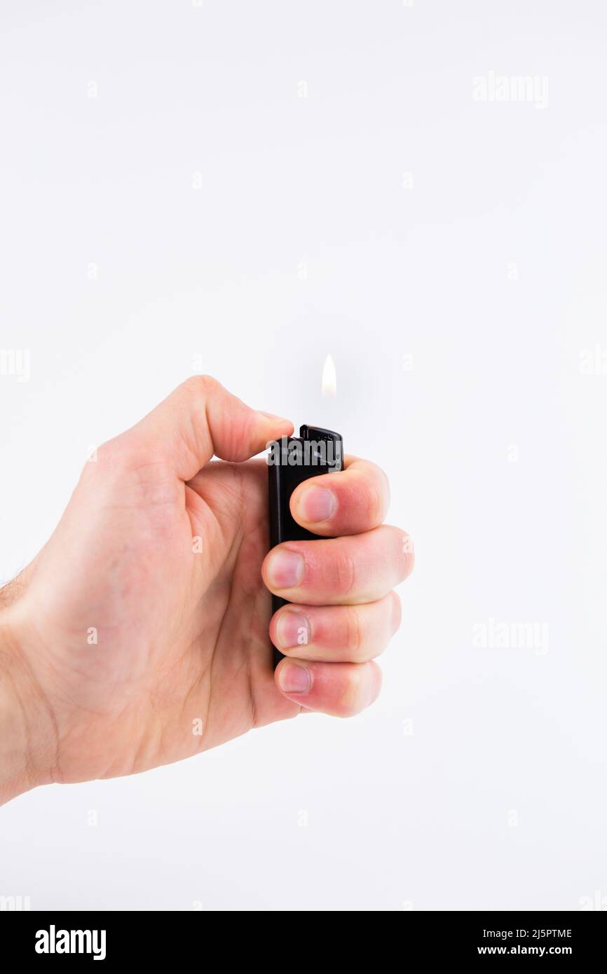 a gas lighter in hand burns fire on a white background Stock Photo - Alamy