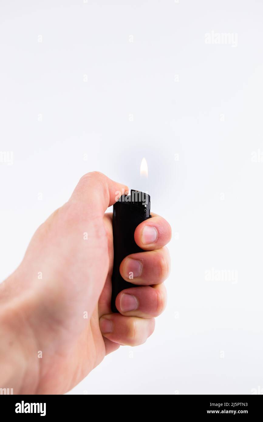 a gas lighter in hand burns fire on a white background Stock Photo - Alamy