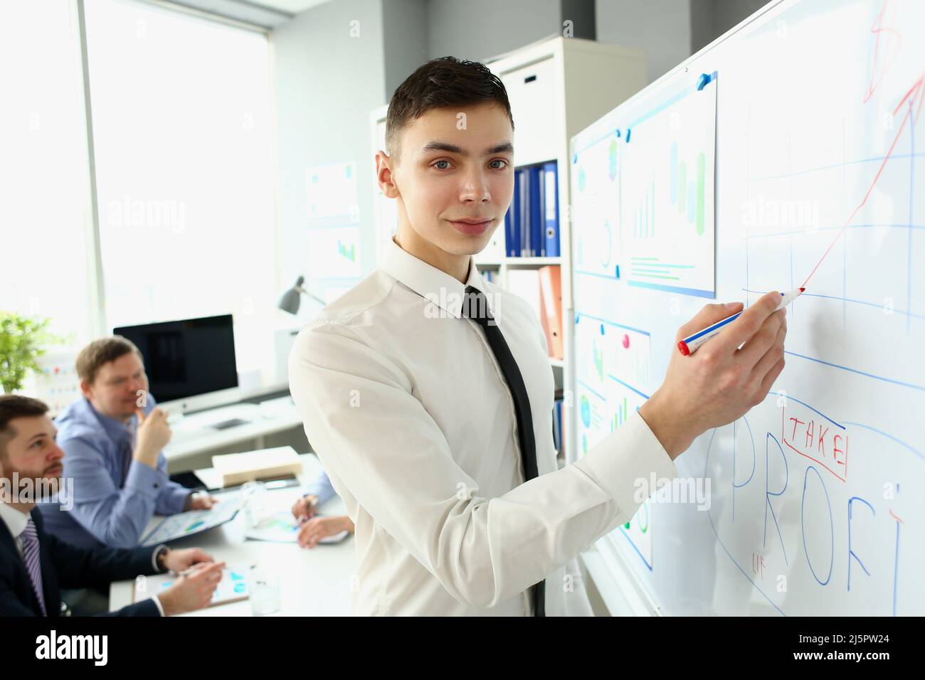 Smart man making presentation of profits for colleagues Stock Photo - Alamy