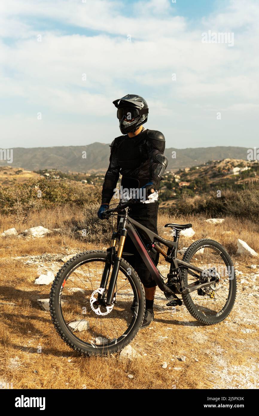 Downhill rider fully equipped with protective gear and his bicycle ...