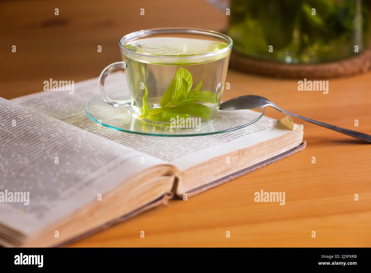 Mint tea in transparent glass tea cup on opened book Stock Photo - Alamy