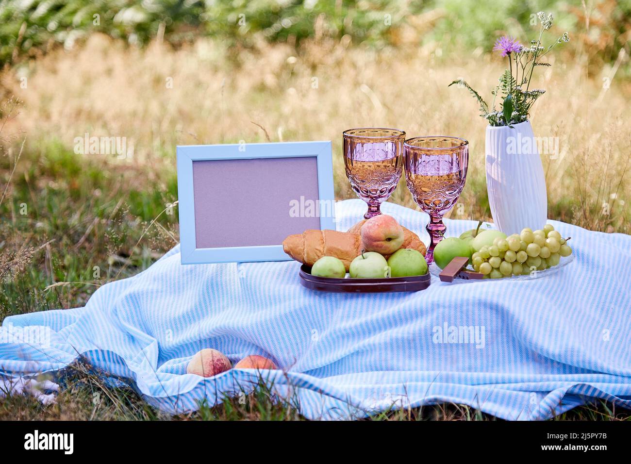 Aesthetic summer picnic with croissants, fruits, chocolate and glass of ...