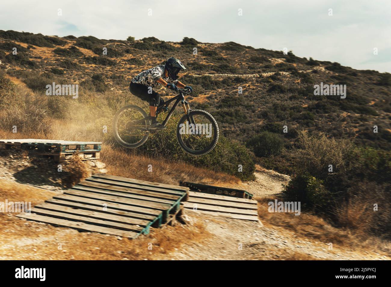 MTB bike rider jumping during downhill ride on his bicycle in mountains ...
