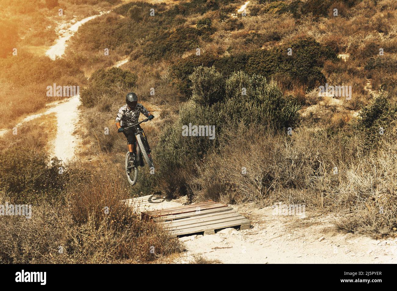 MTB bike rider jumping during downhill ride on his bicycle in mountains ...