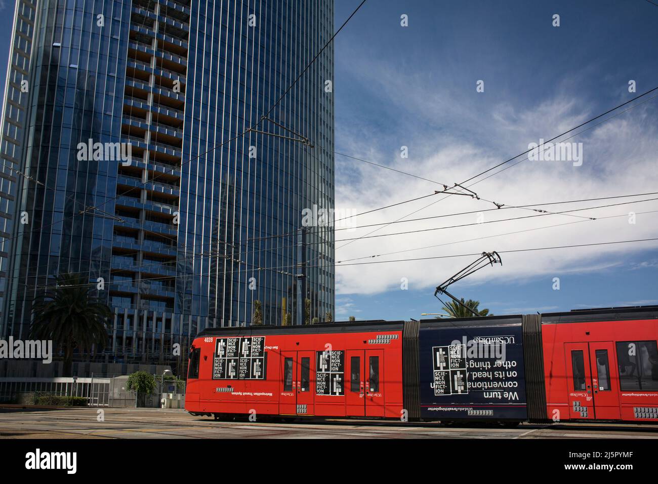 Red streetcar in front of a modern skyscraper in San Diego Downtown ...