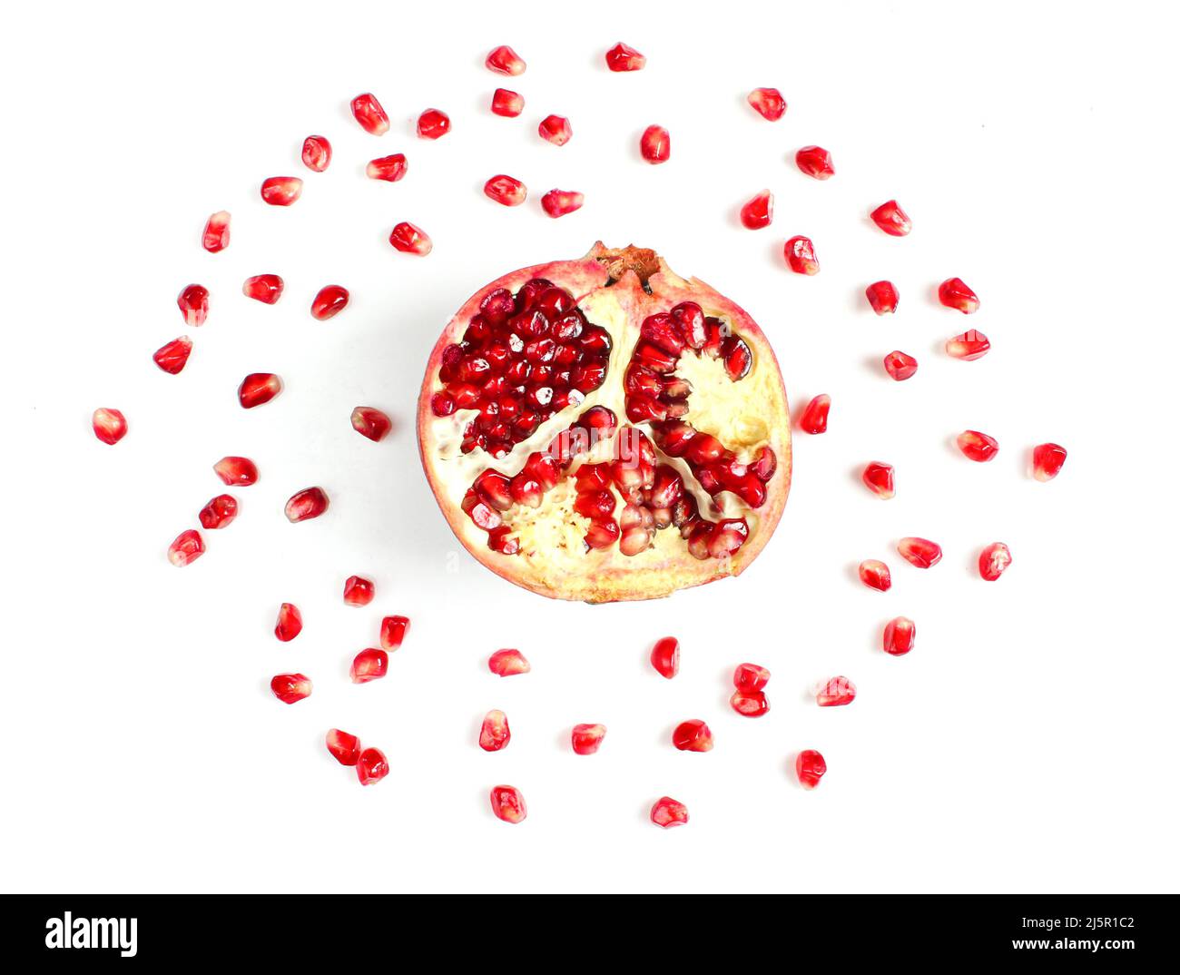 Pomegranate half and seeds isolated on white background Stock Photo - Alamy