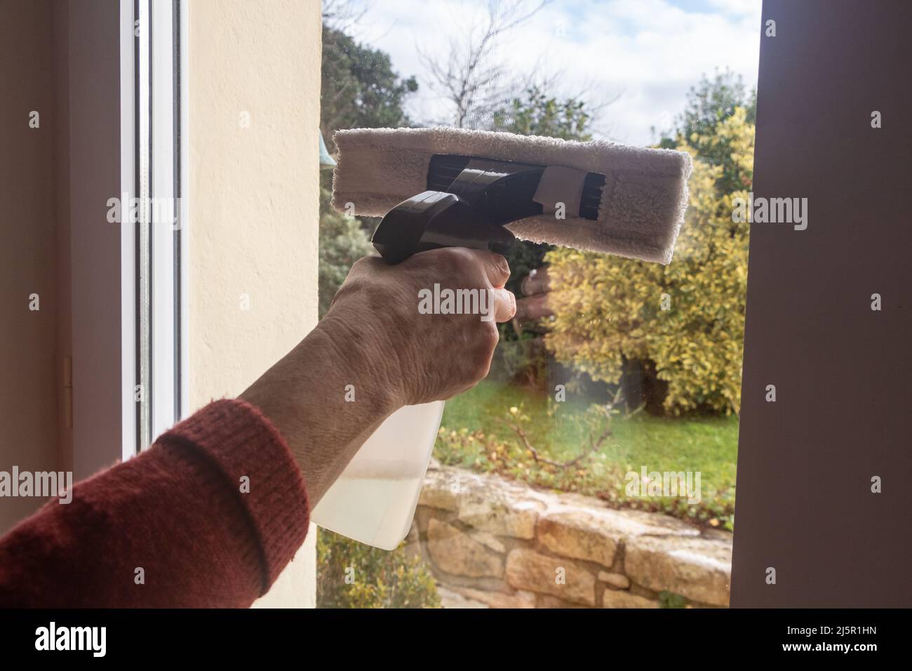 To wash the window of a door with a scraper Stock Photo - Alamy