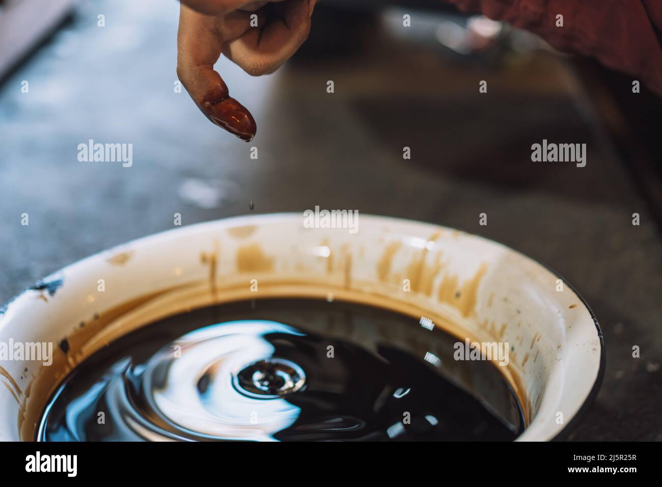 Finger over used dirty engine oil in basin Stock Photo - Alamy