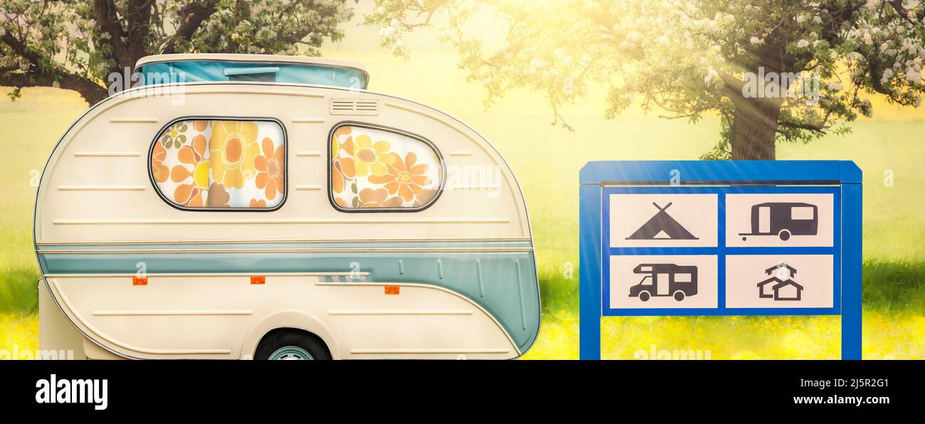 Retro seventies caravan with camp site greeting sign in front of ...