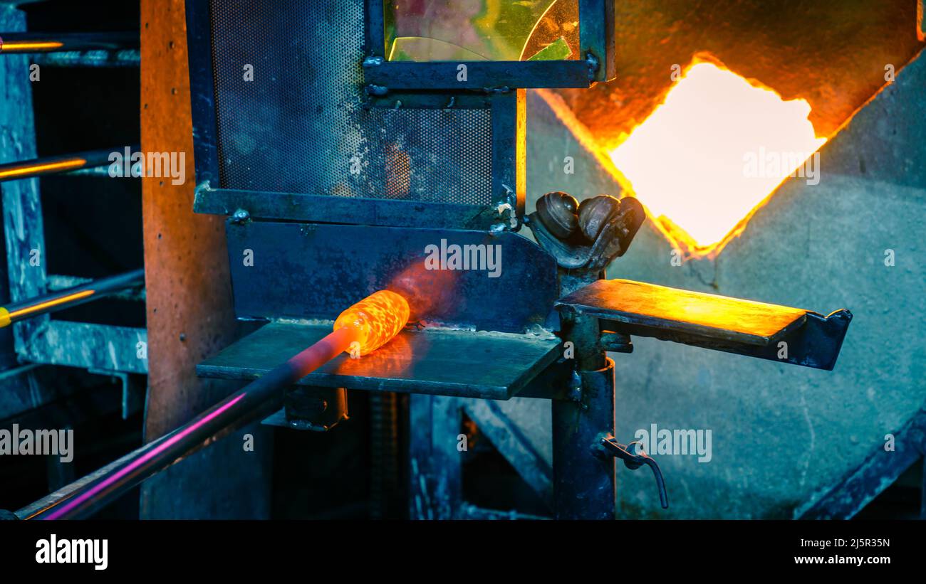 Shaping the hot glass gather during glassblowing process Stock Photo ...