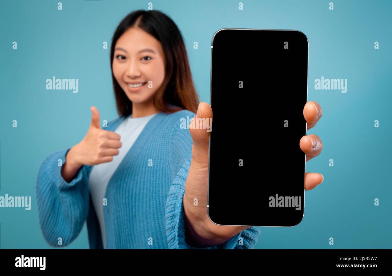 Asian lady showing smartphone with blank screen and thumb up Stock ...
