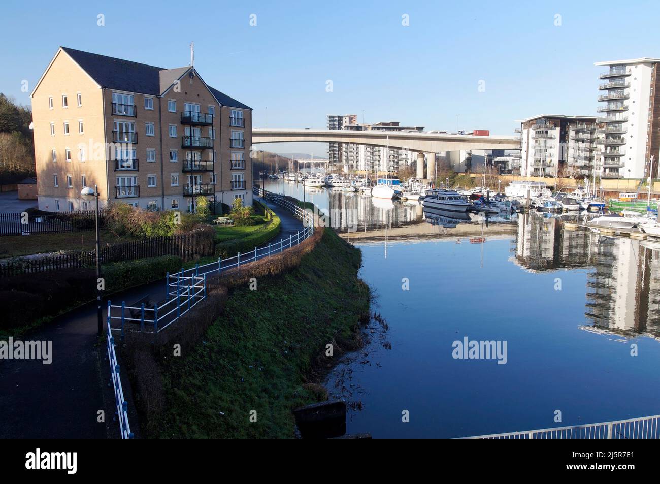 Clear blue sky on a sunny day, Ely river as it enters Cardiff Bay and ...