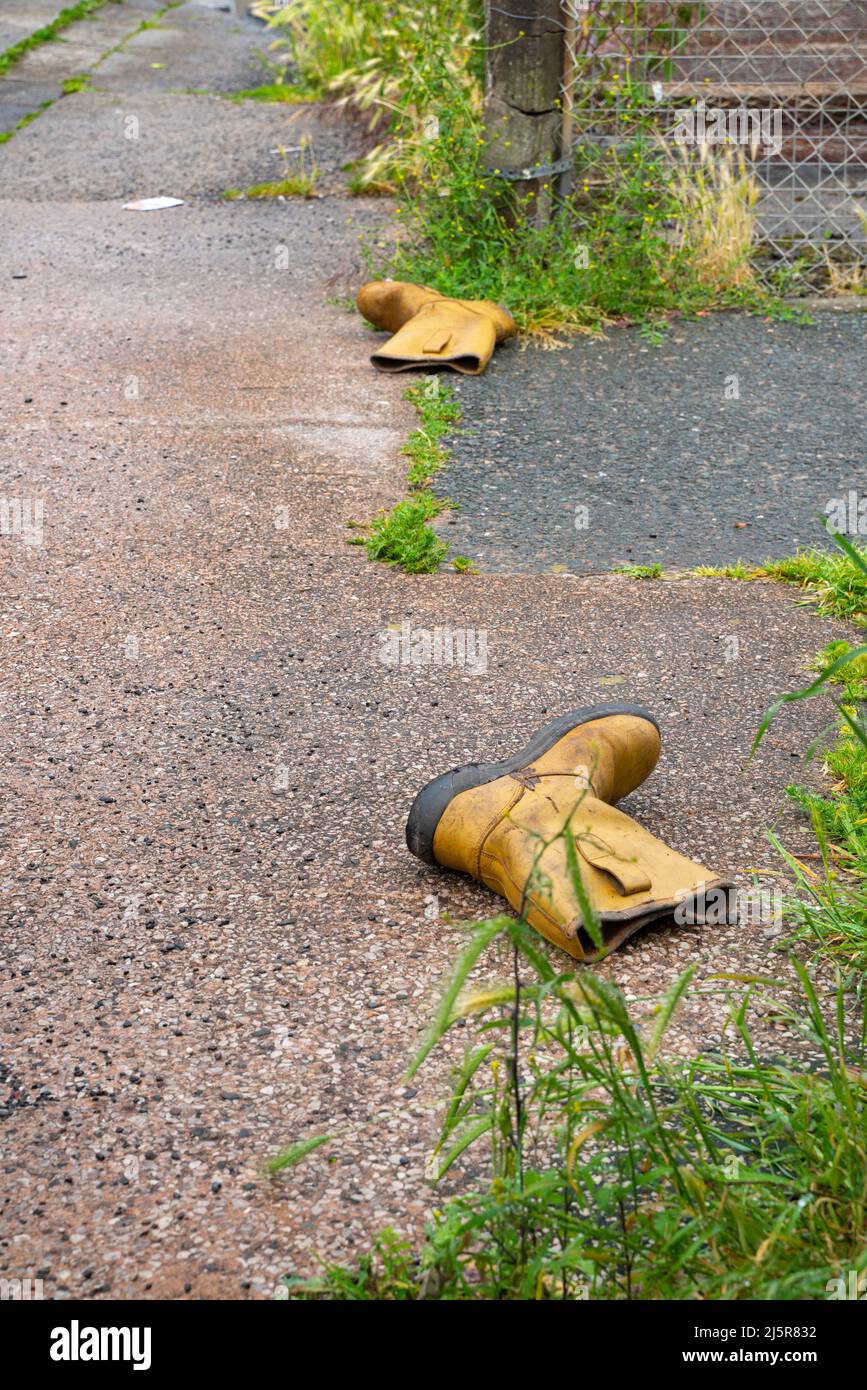 Pair of Yellow Rigger Boots discarded in town back street Stock Photo ...