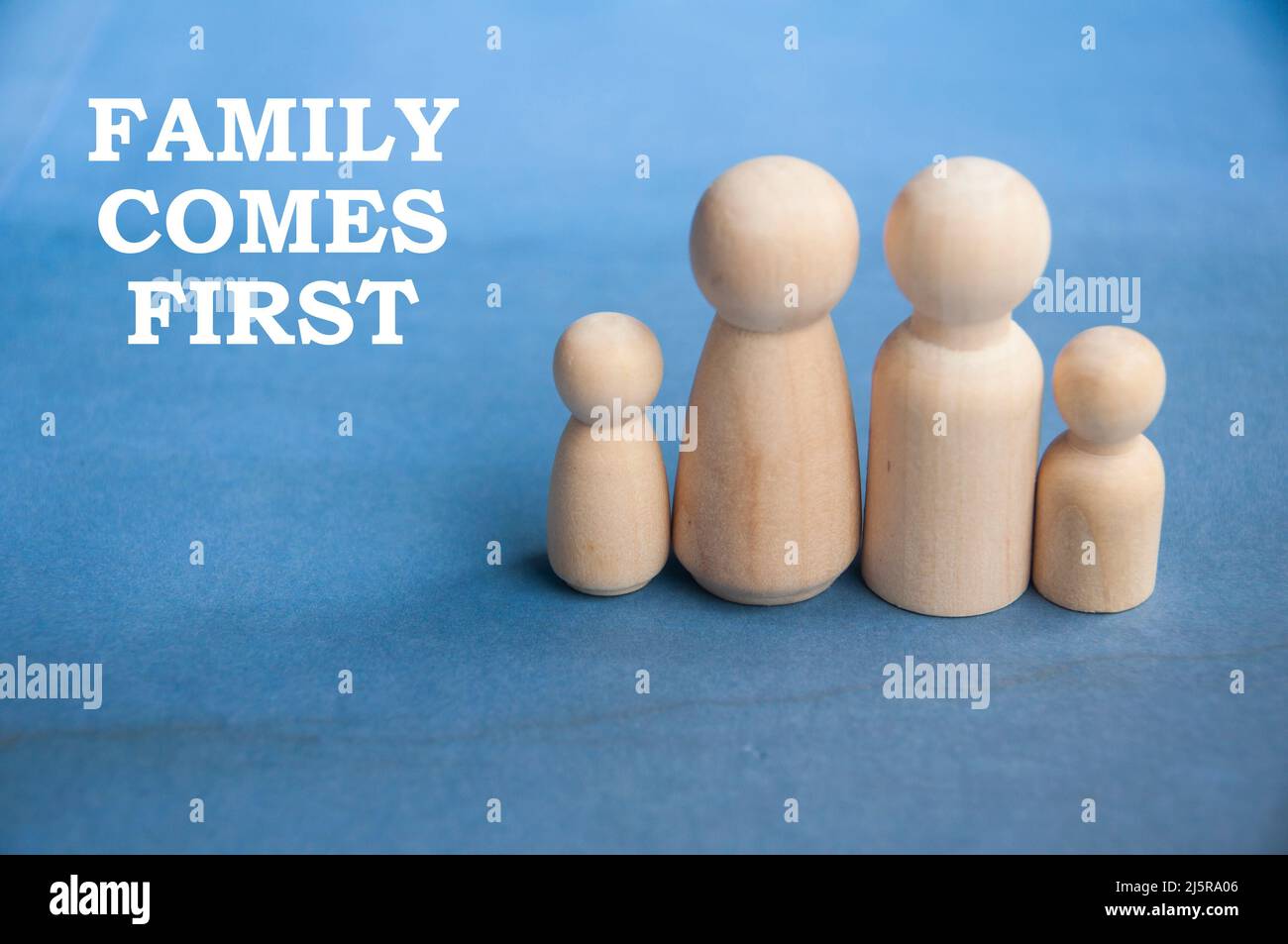 Family comes first text with family wooden dolls background. Family ...