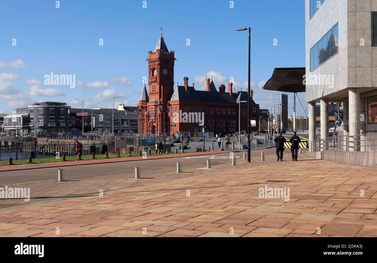 Armed police patrol in front od Welsh Assembly. Road barrier is up in ...
