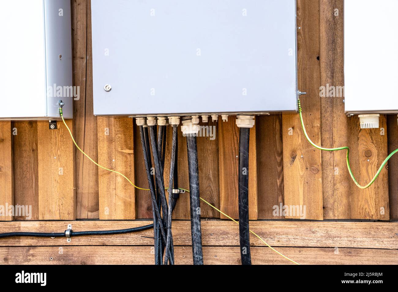 electrical panels and electrical cables connected to them on the wall ...