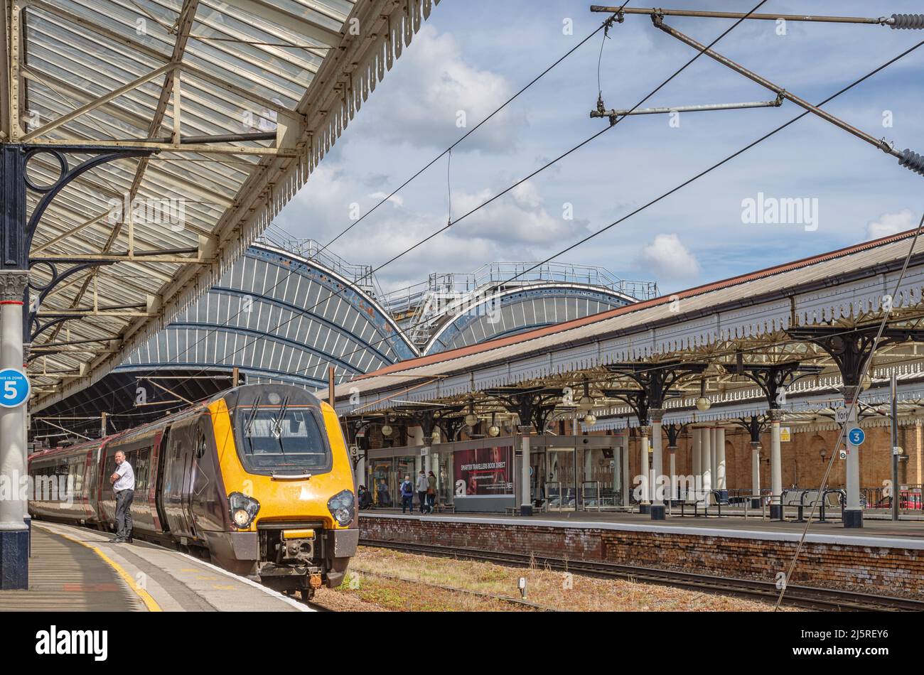 A train stands at a historic platform of a railway station. A crew ...