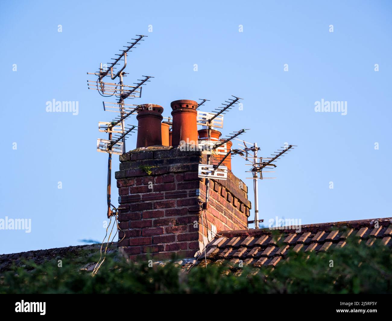 multiple TV Ariel's and antenna on the chimney stack of a house Stock ...