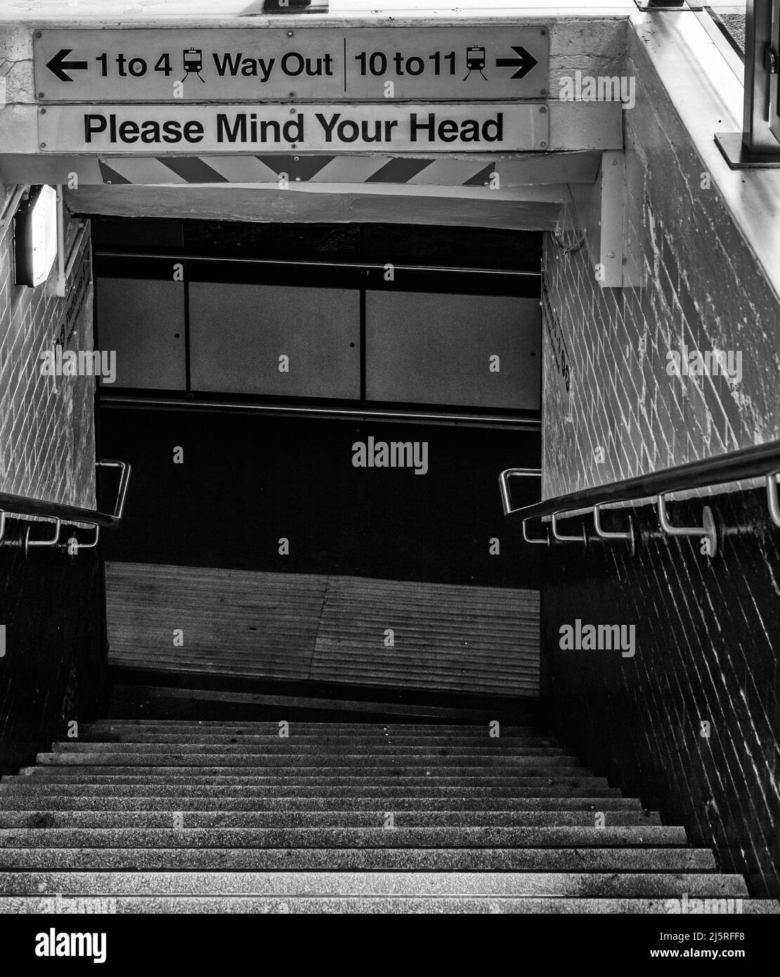 Entrance to a station subway. Steps lead down to a passage and signs ...