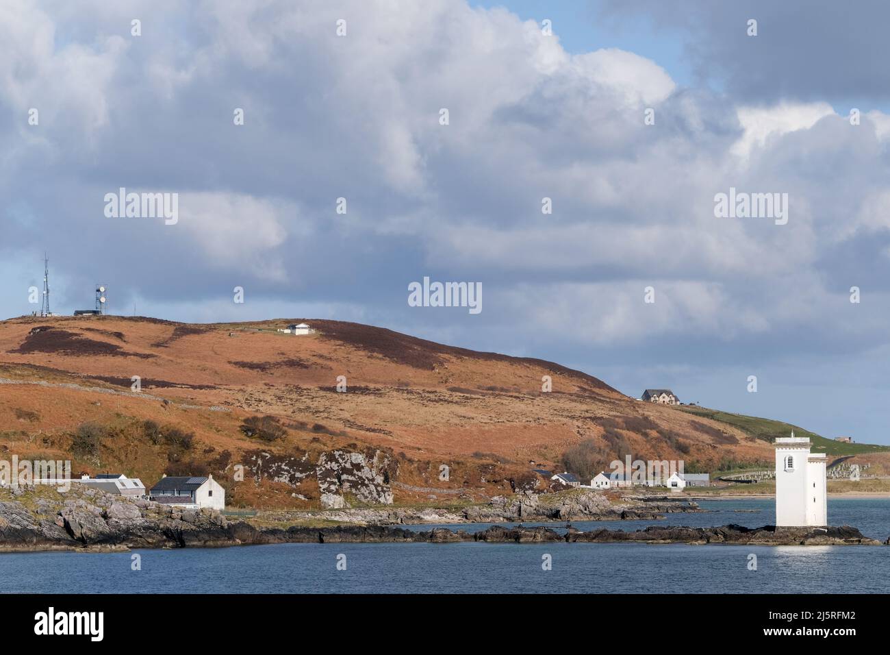 The distinctive white painted lighthouse by Port Ellen harbour, Islay ...