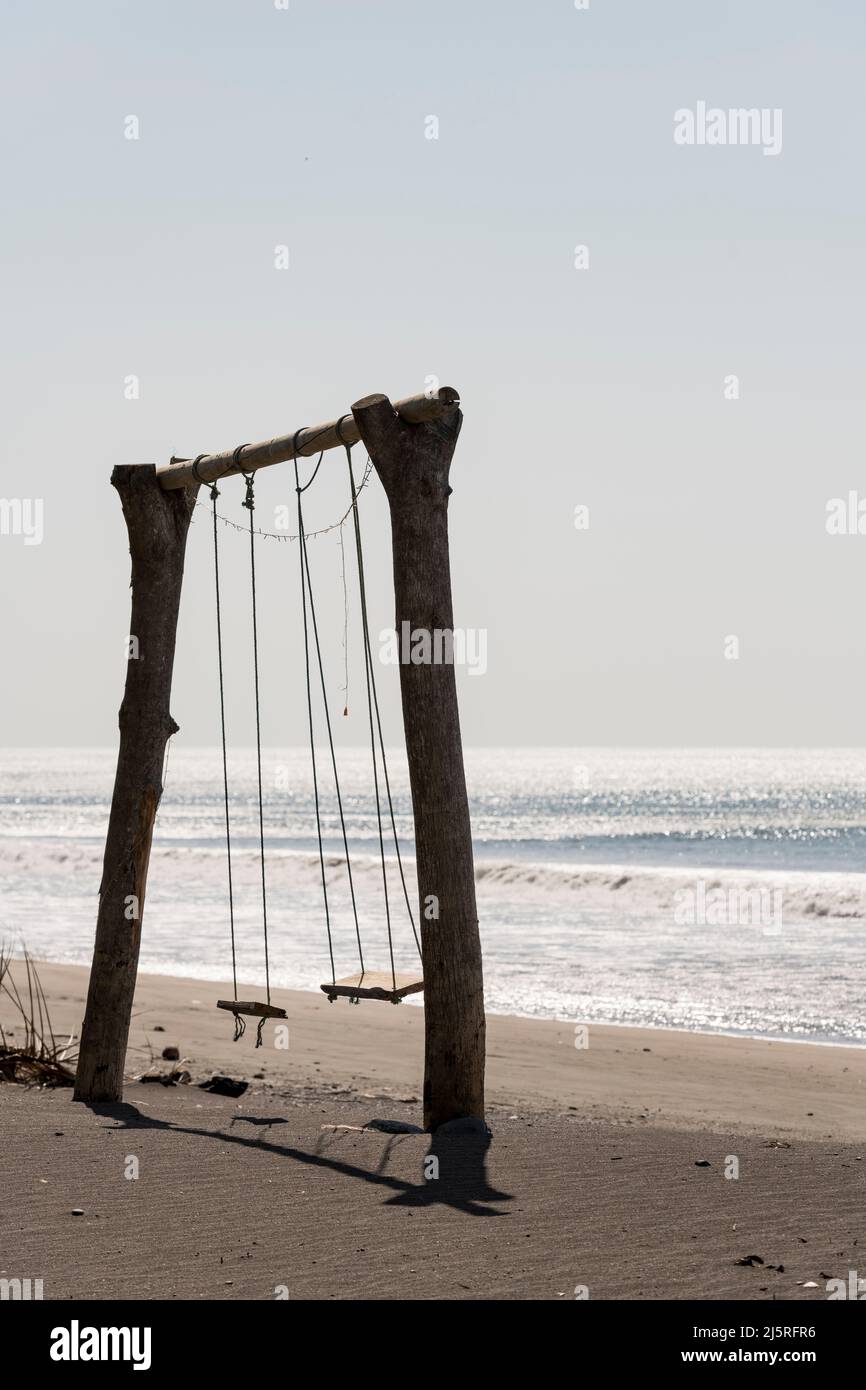 Wooden swing with ropes overlooking the sea. Swing on seashore ...