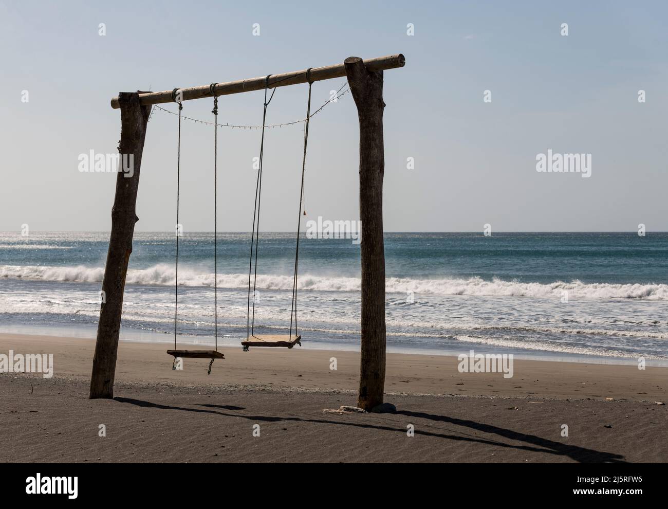 Wooden swing with ropes overlooking the sea. Swing on seashore ...