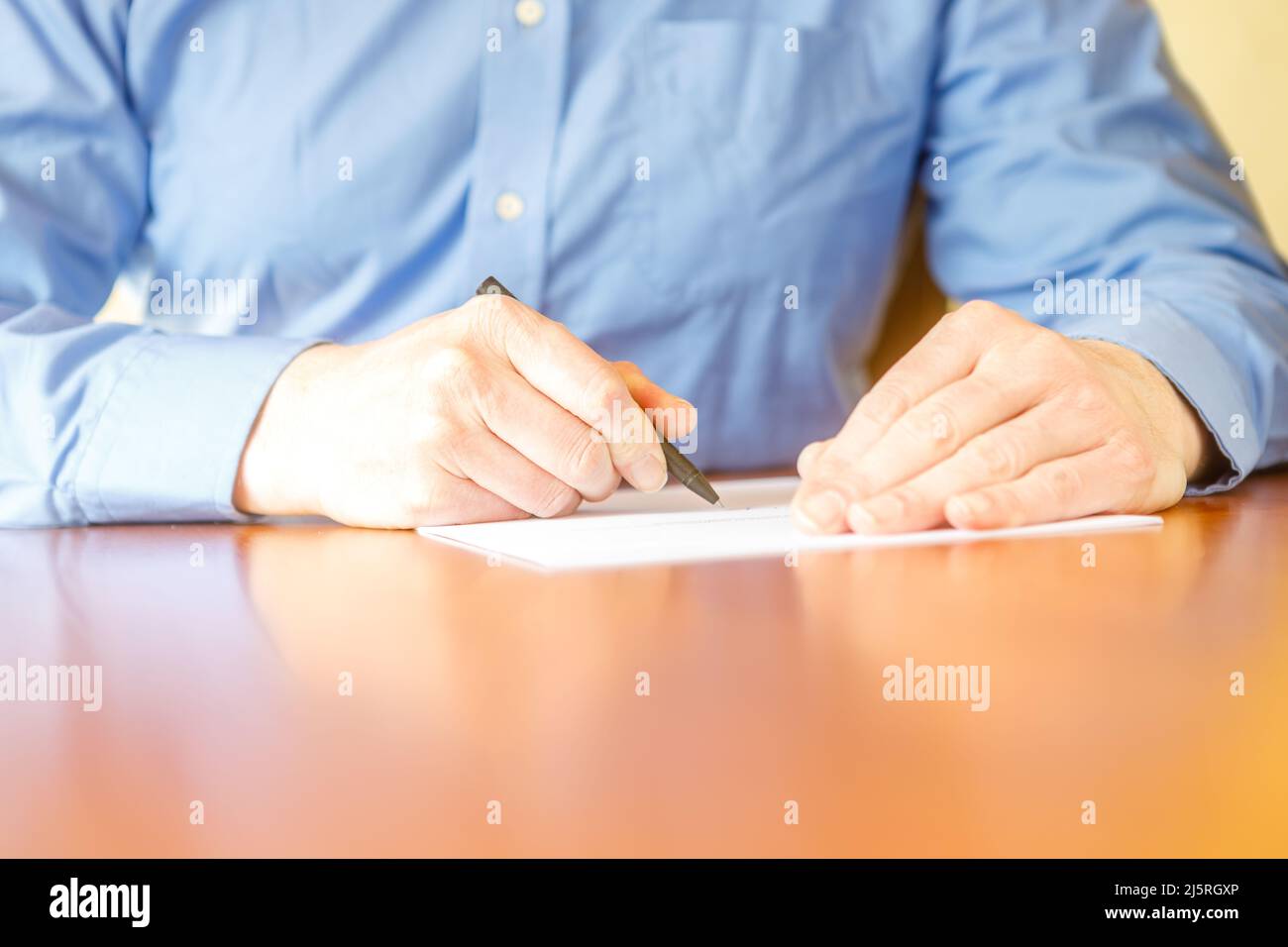 A man signs a contract on desk Stock Photo - Alamy
