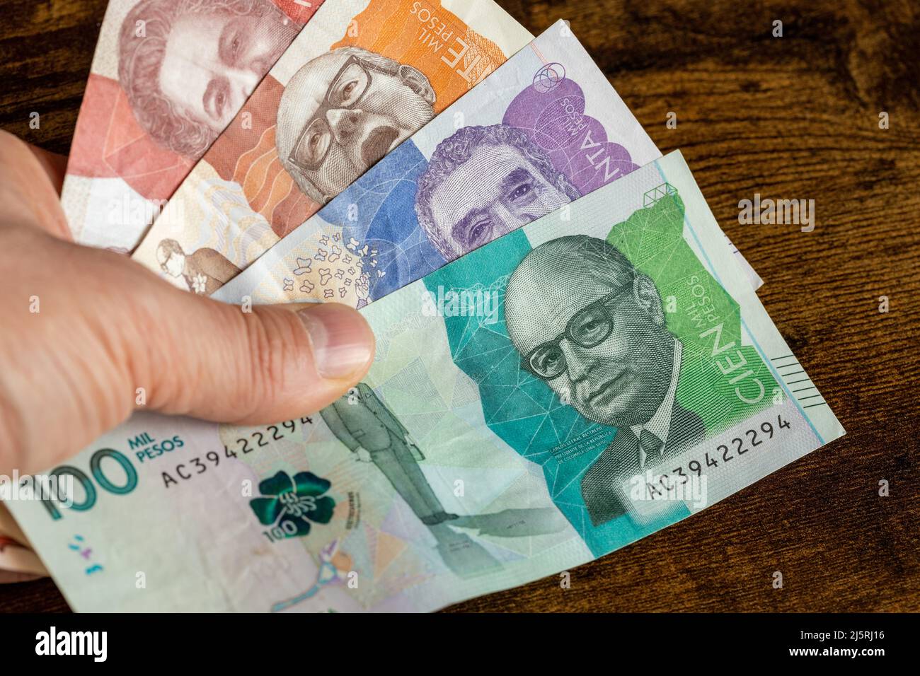 A file of Colombia banknotes held in the hands Stock Photo - Alamy