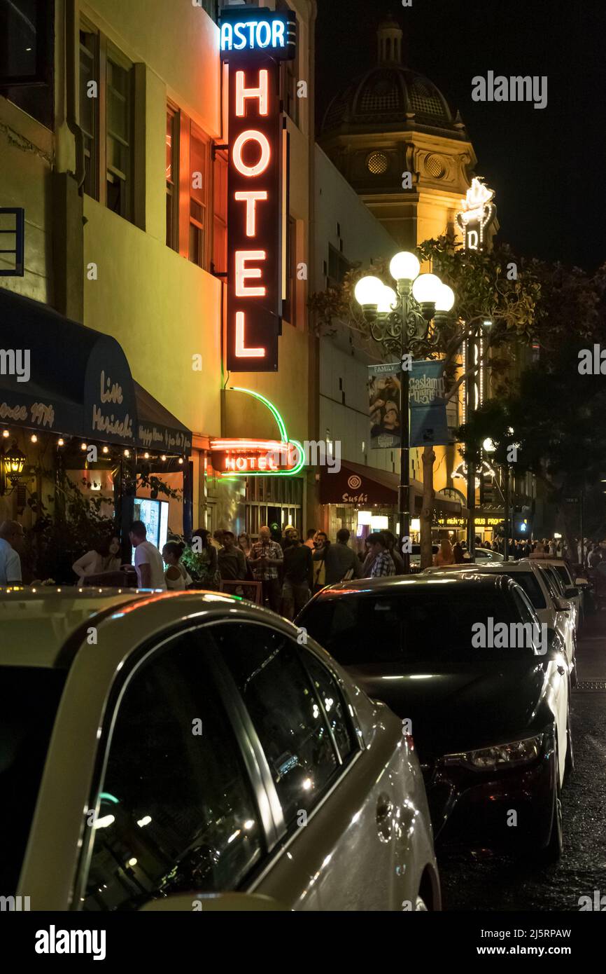 Night shot of the illuminated Astor Hotel neon sign and the lively ...