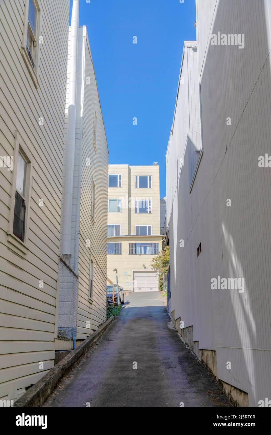 Uphill alleyway in the middle of flat residential buildings in San ...
