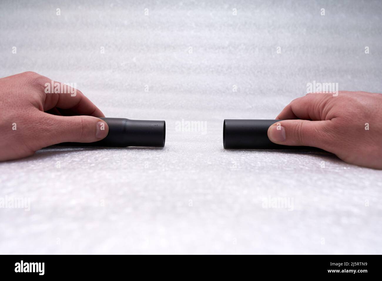 2 hands push steel pipes, also bar together. Connecting the metal parts ...