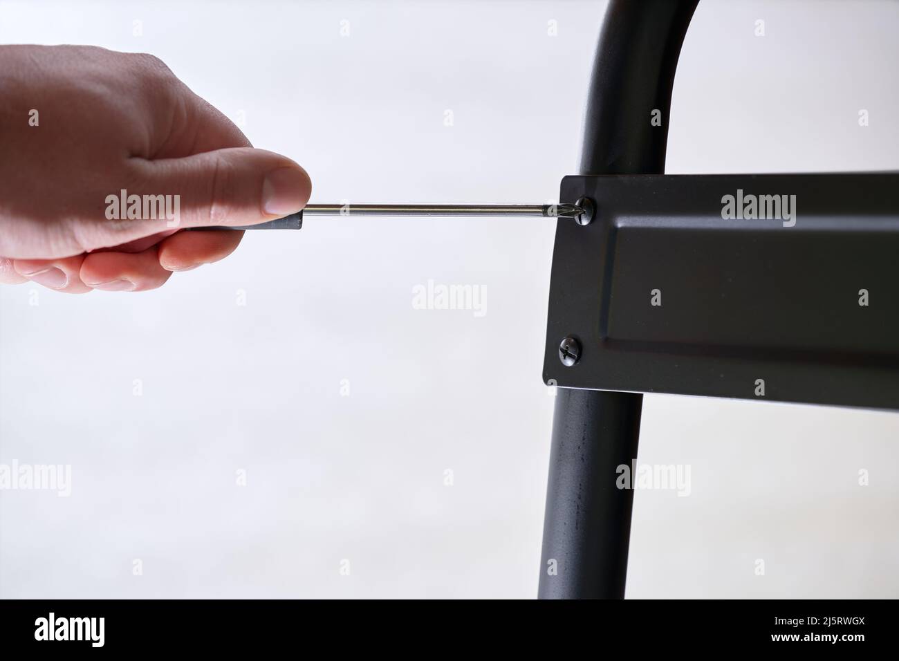 Hand with screwdriver tool, works on steel construction. Professions in ...