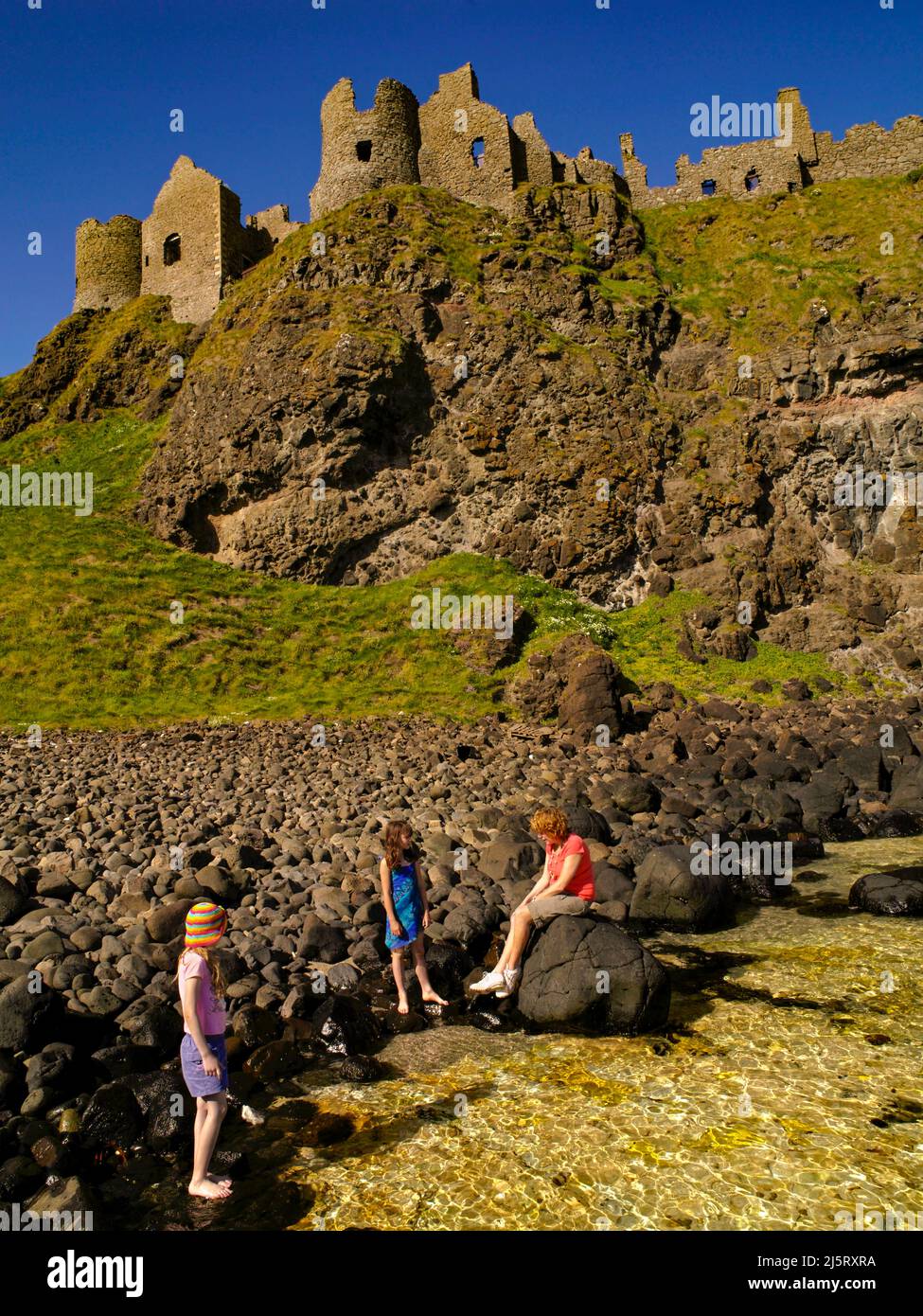 Children playing with their mother at Dunluce Castle, Portrush, White ...