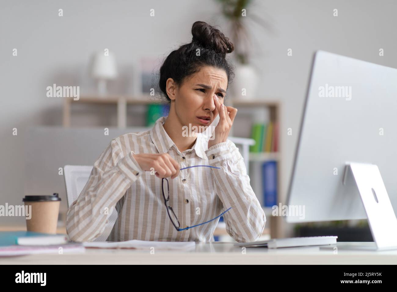 Tired unhappy female manager rubbing eyes and crying, sitting at ...