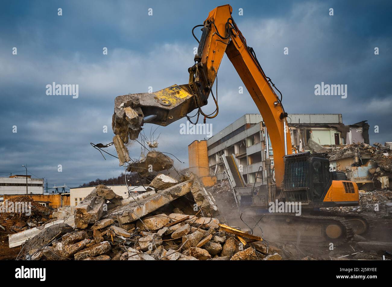 Excavator with hydraulic press breaks concrete leftovers Stock Photo - Alamy