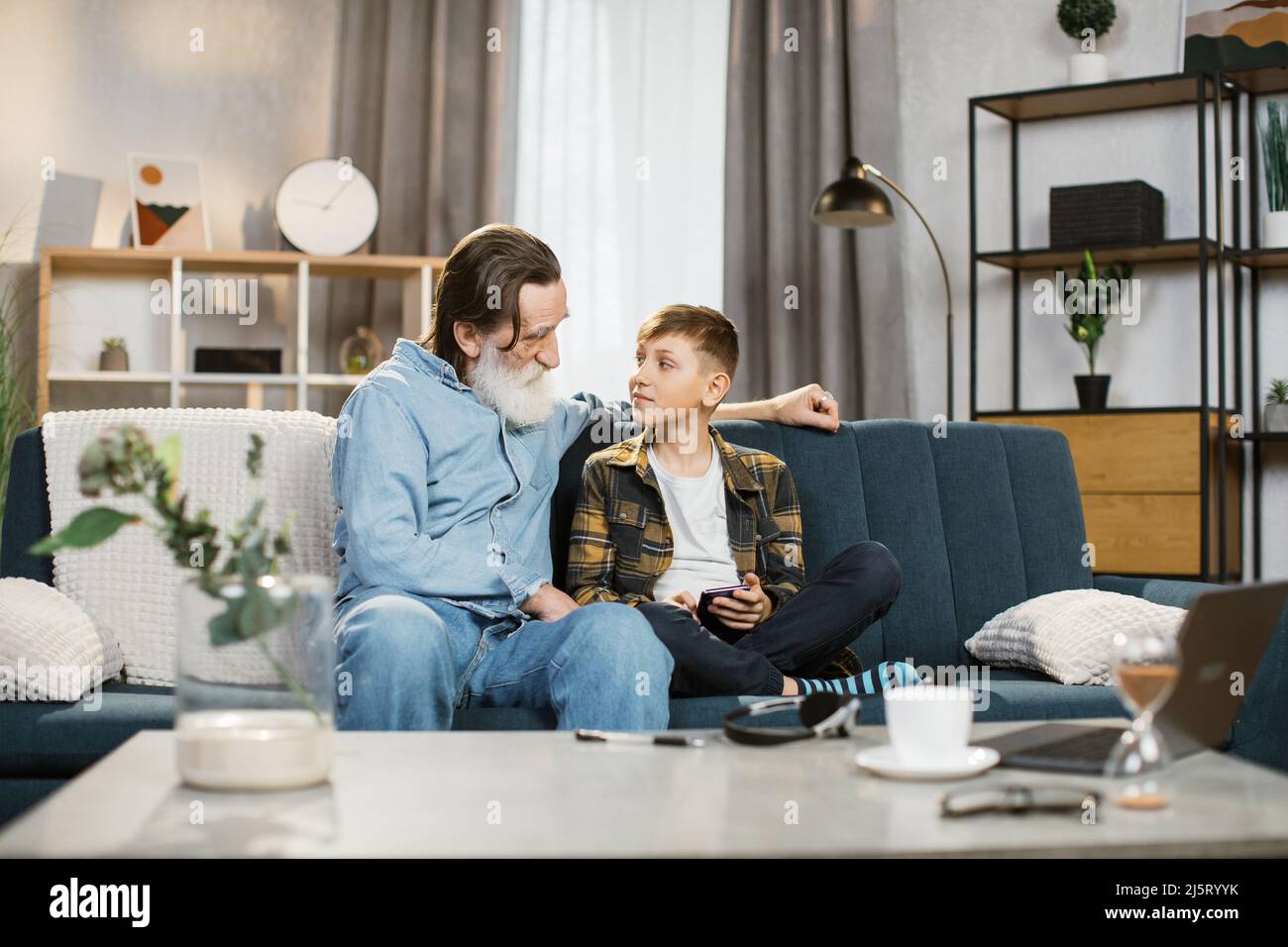 Happy grandfather with grey beard cuddling smiling small child boy ...