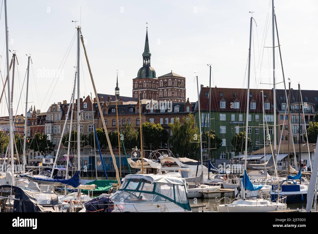 Boats and yachts in front of old buildings and the church. Facades of ...