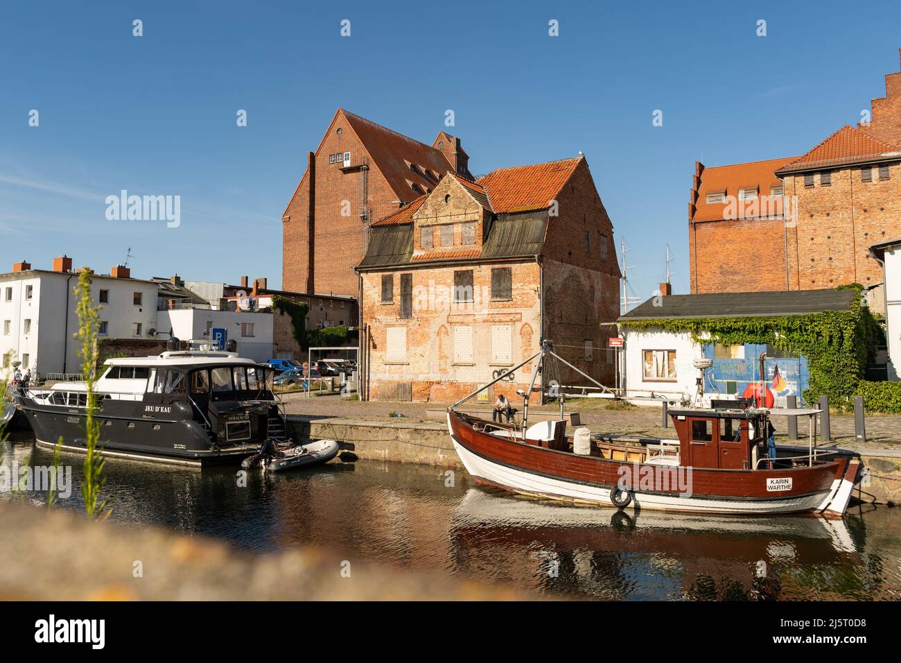 Two boats in the front of old hanseatic buildings in the bay area. Old ...