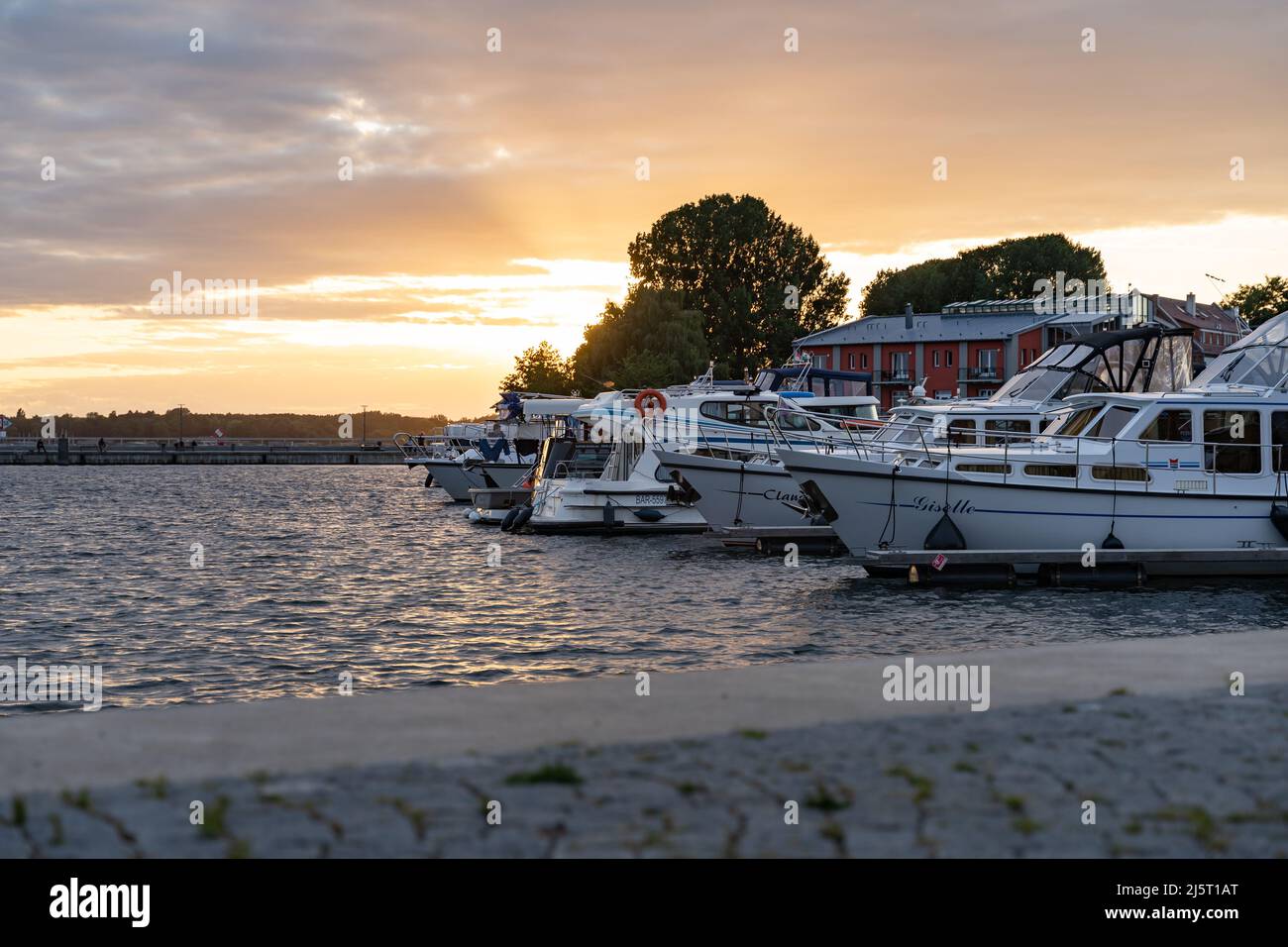 Boats and yachts in the harbour in front of the sunset. Beautiful ...