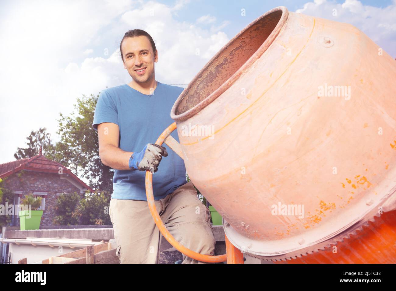 Happy man stand holding cement mixer at home construction Stock Photo ...