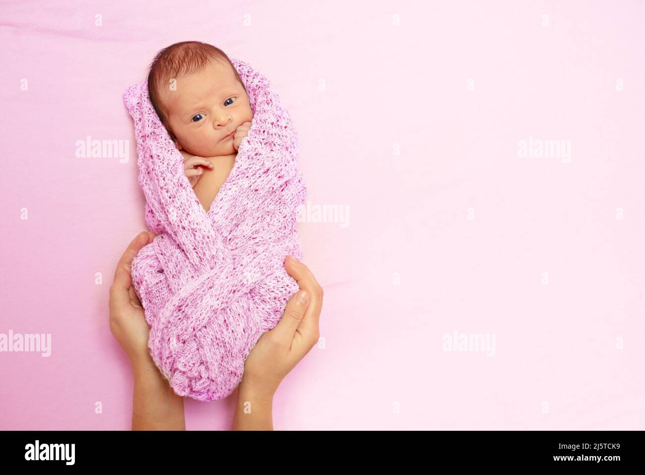 Newborn baby in pink cover with mother's hands, view from above Stock ...