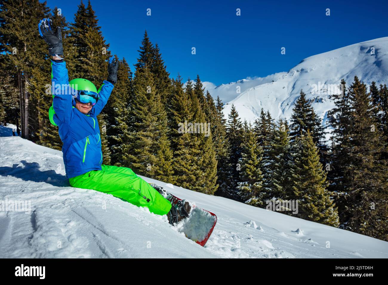 Snowboarder child lift hands up sit on snow in mountains Stock Photo ...