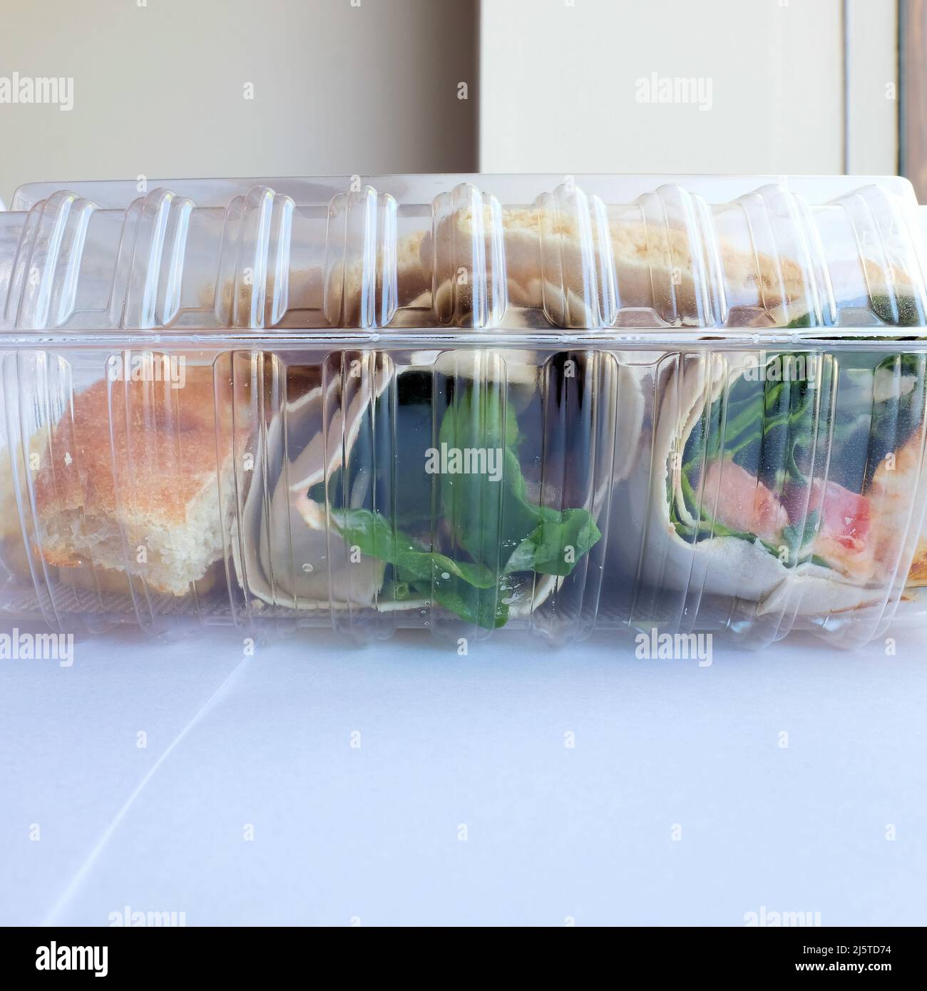 Clear plastic leftover container with a chicken and hummus wrap ...