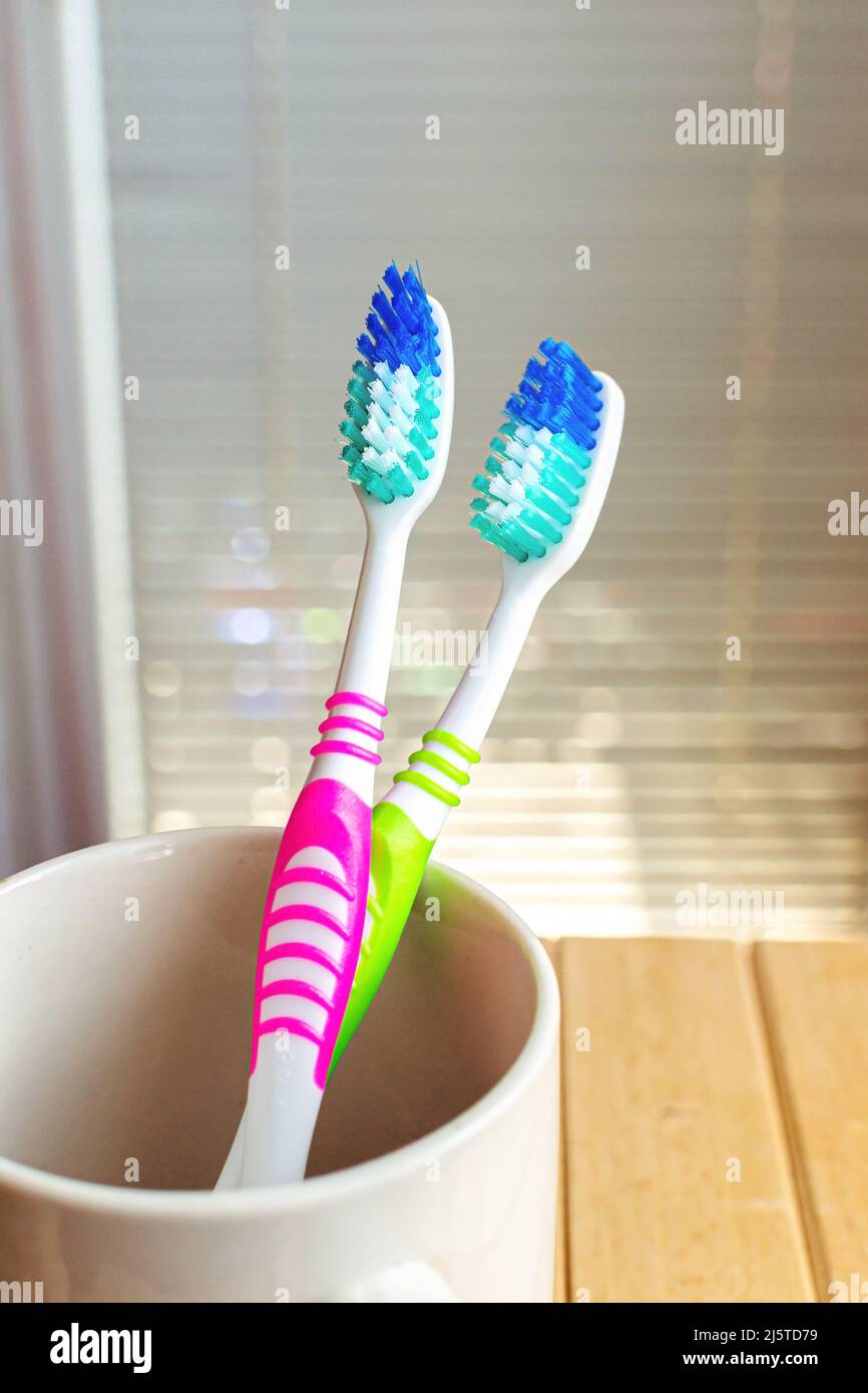 Colorful toothbrushes in the white cup. Dental concept Stock Photo - Alamy